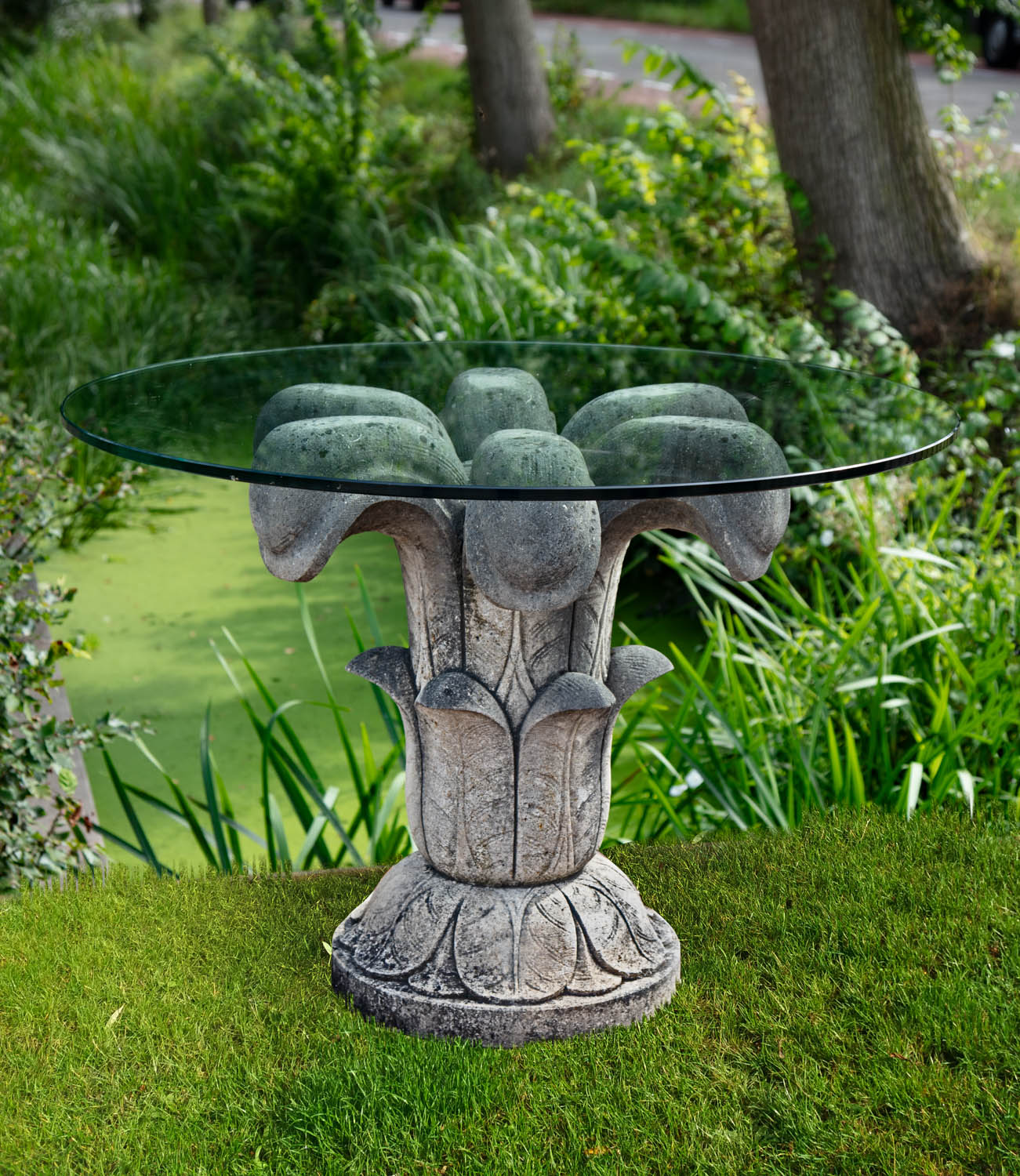 A carved limestone and glass top table - Piet Jonker