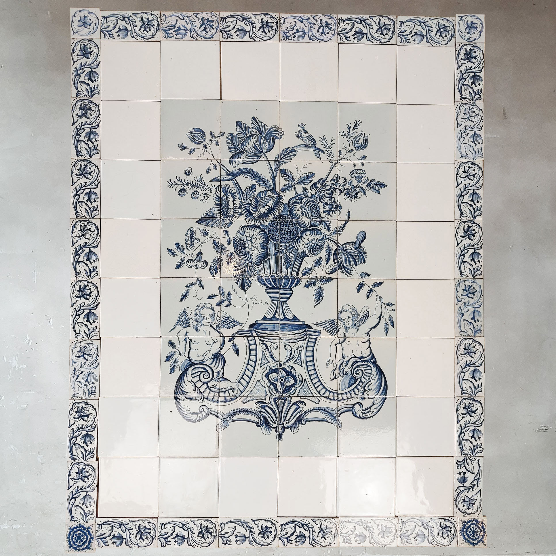 Blue painted tile tableau of a flower vase with angels - Piet Jonker